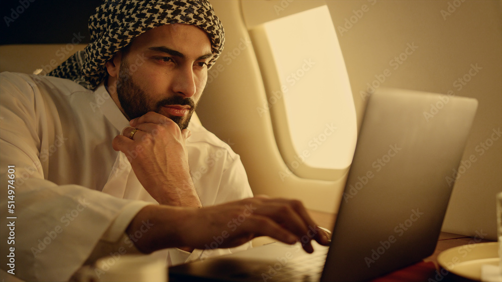 Thoughtful muslim working laptop on business trip closeup. Rich man ...