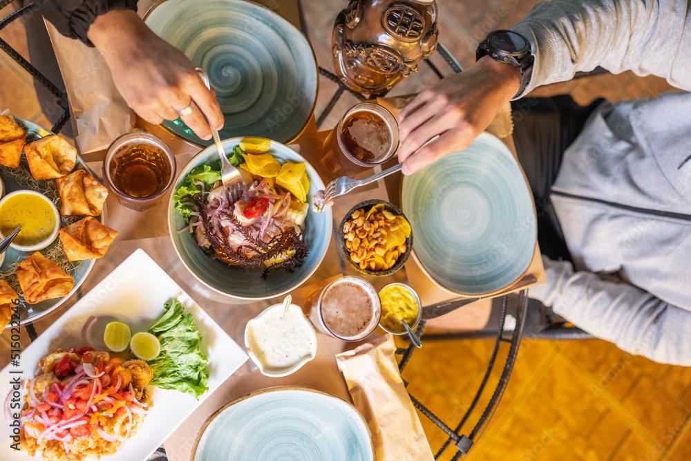 Table of a restaurant with people eating peruvian dishes Stock Photo ...