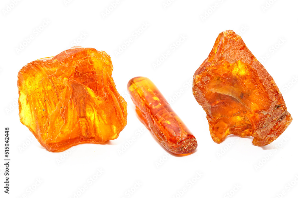 Pieces of amber of different shapes in yellow color on a white ...
