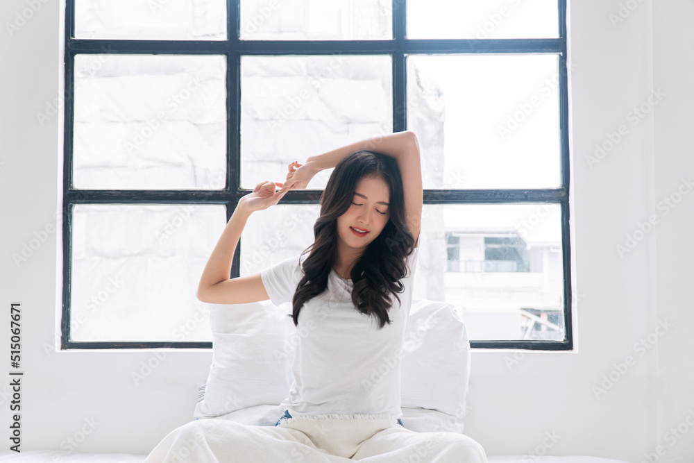 Healthy asian woman waking up relax muscles beside window early in ...