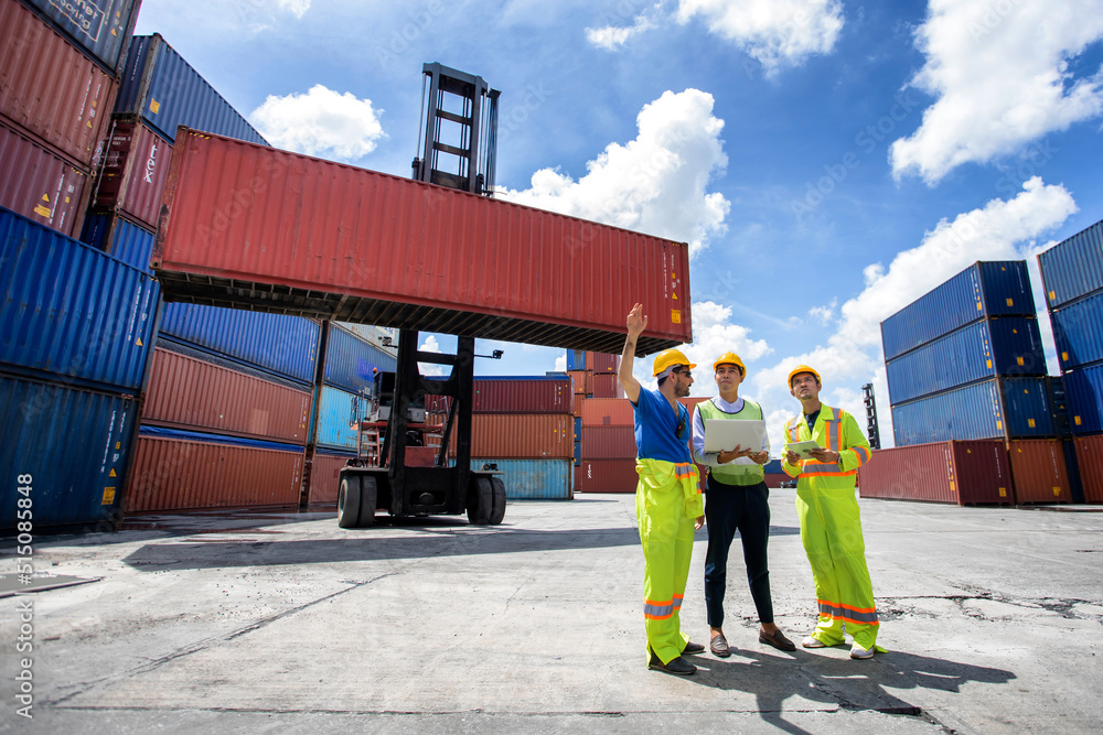 Manager standing and meeting with his staff in container depo company area. worker working ...