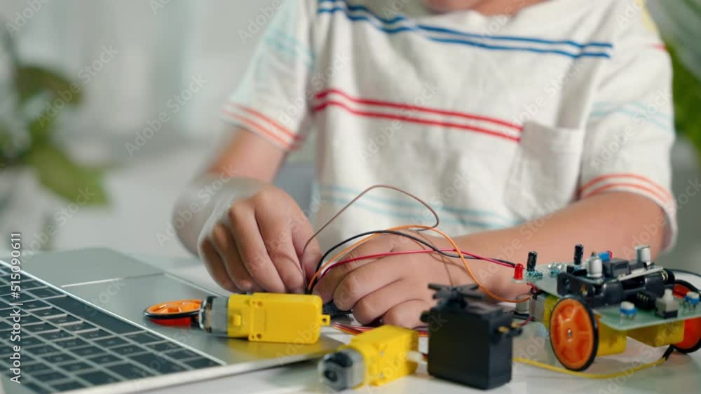 Asian kid boy plugging energy and signal cable to sensor chip with ...