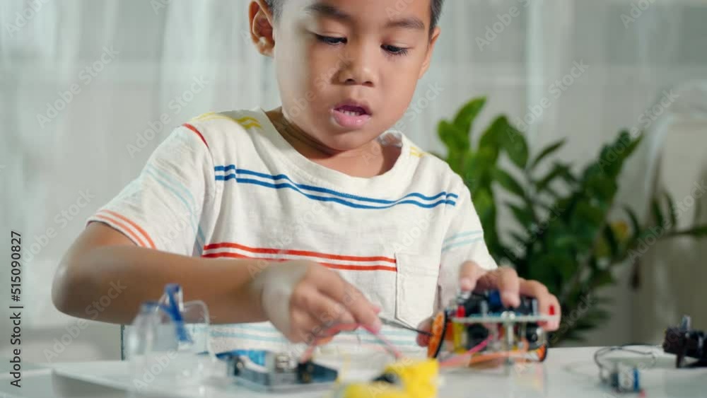 Little child trying assemble build wheel to car toy, Asian kid boy ...