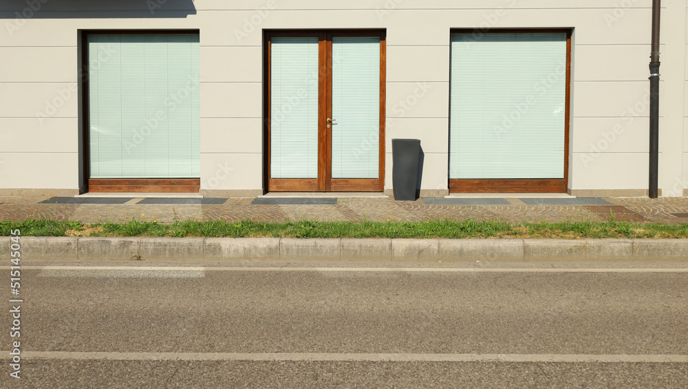 Small office with door and storefronts closed with venetian blinds ...