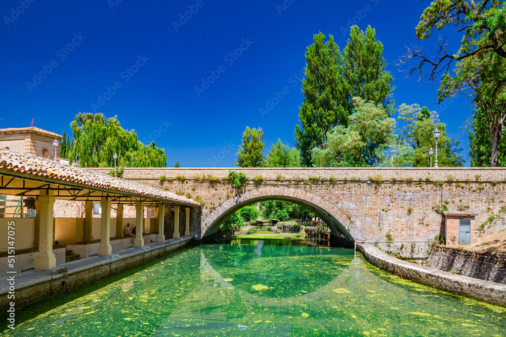 The ancient wash-house and the masonry bridge over the river, in the ...