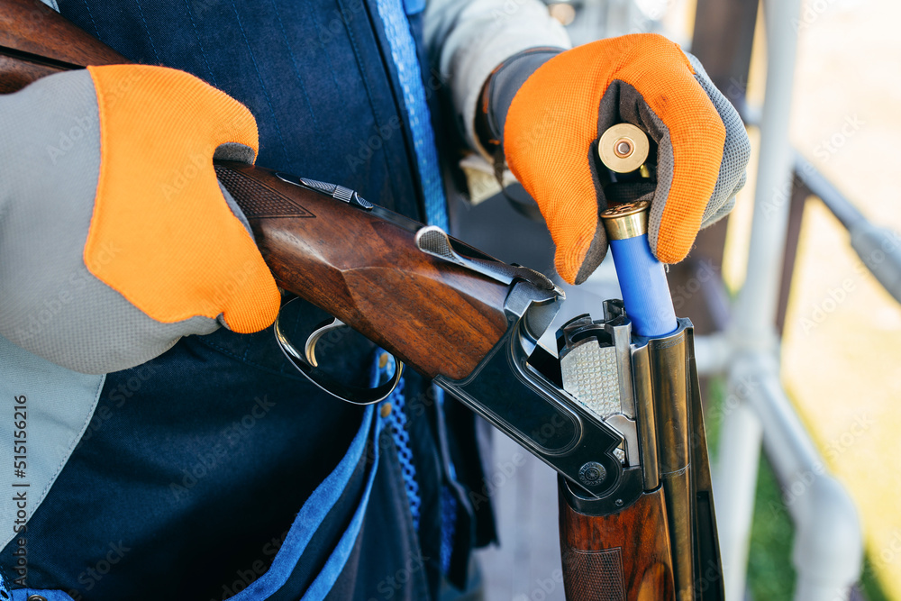 Shooter opens the shotgun bolt and inserts cartridges with shot Stock ...