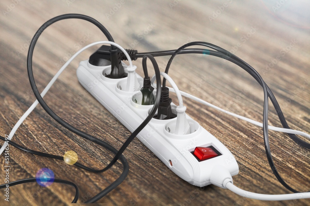 Unplugged electric appliance plug over switched off white power strip ...