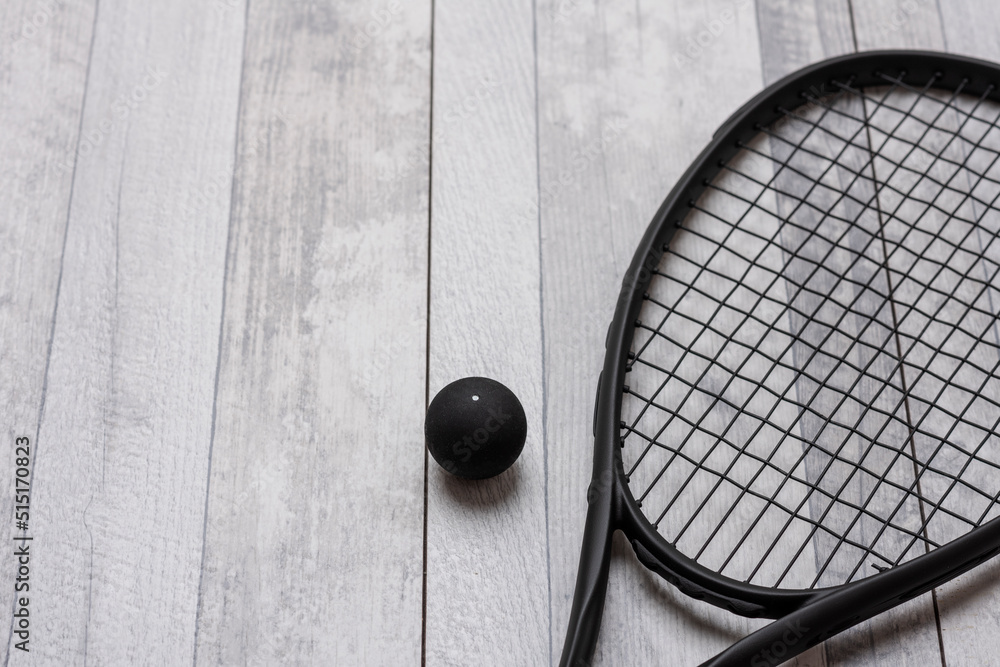 Black squash racket and ball on grey court. Horizontal sport theme ...