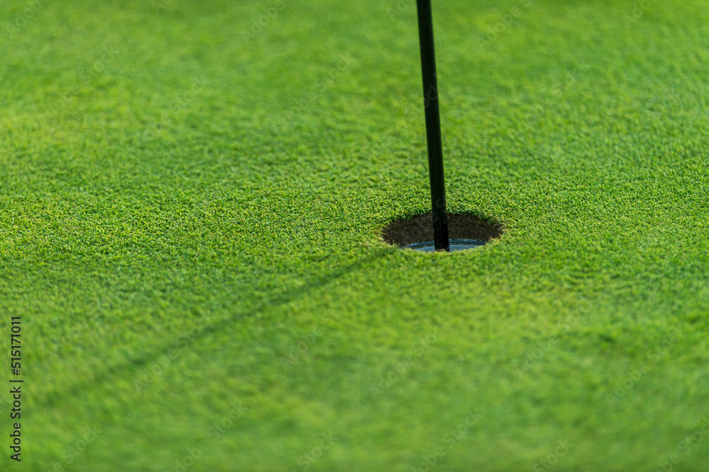 Flag and hole at the beautiful golf course. Horizontal sport theme ...