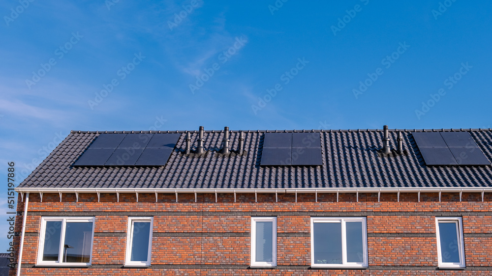 Newly build houses with solar panels attached on the roof against a ...