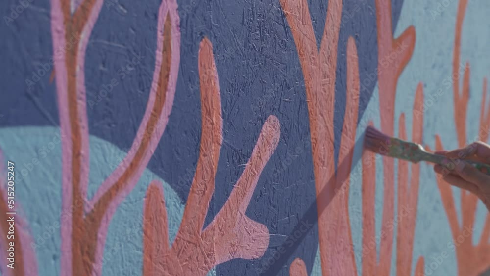 A dynamic rearward footage of hand painting a wooden wall while ...