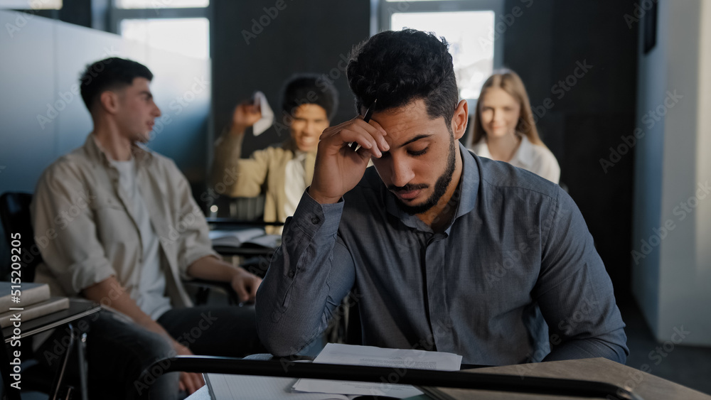 Frustrated oppressed indian student sitting in class lonely young guy ...