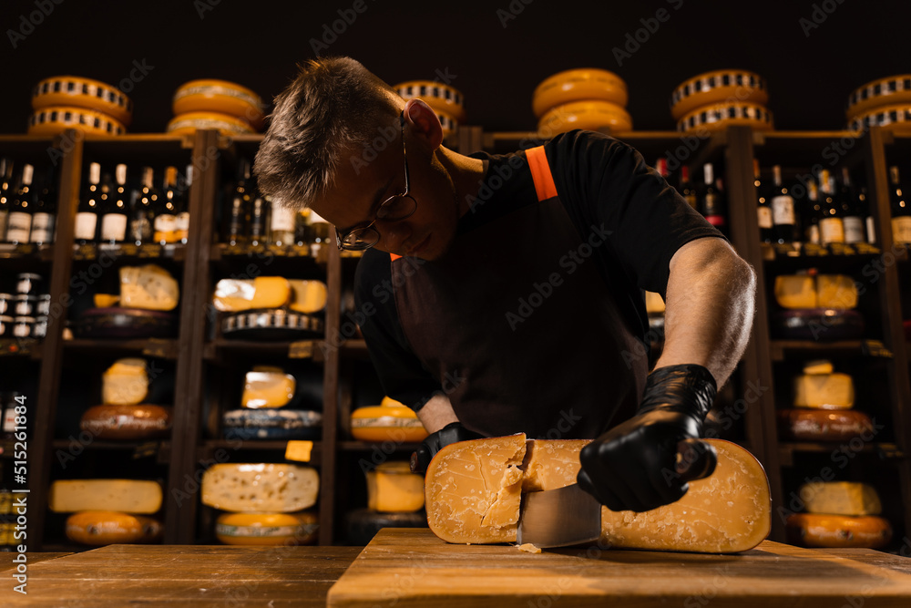 Fotografia do Stock: Handsome man worker of cheese shop cut limited ...
