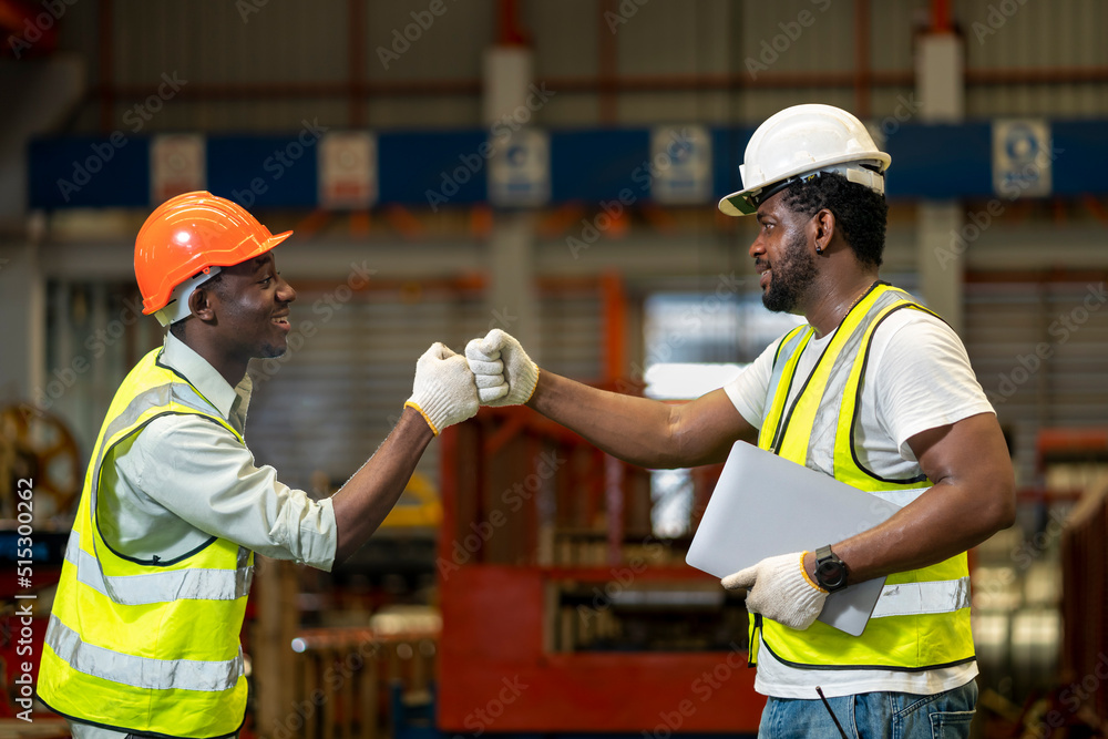 Team of African American industrial worker is doing fist bump while ...