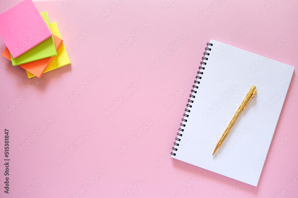 Notebook with gold pen on one side and stack of stickers overlay on ...