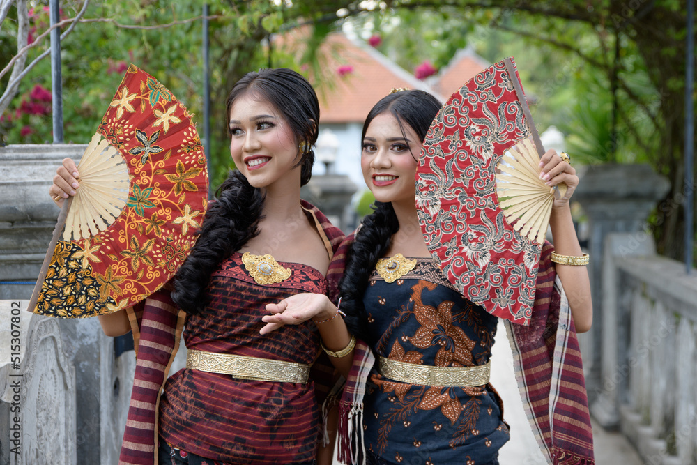 Beautiful girls in Balinese traditional costume with a fan, in the ...