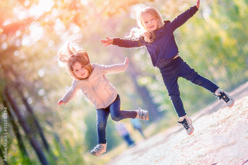 Two little girls jumping outdoors Stock Photo | Adobe Stock