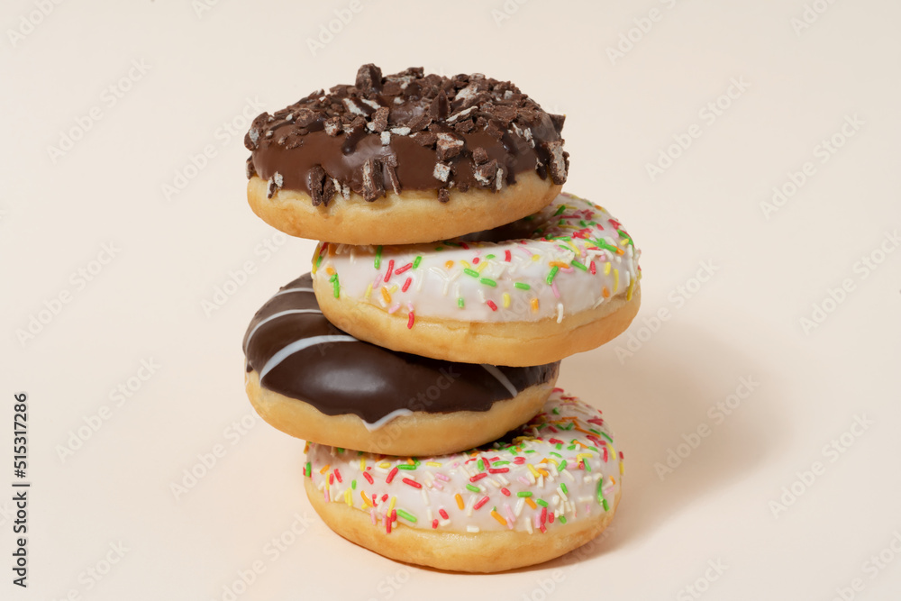 Colorful glazed donuts arranged verticaly on the beige background Stock ...