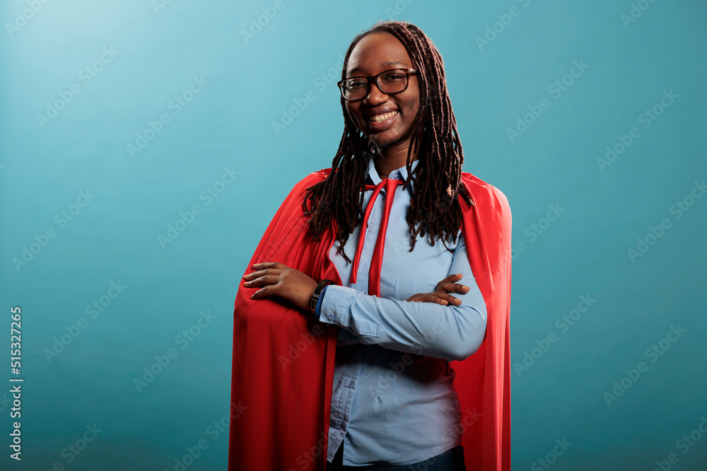 Portrait of happy brave woman with superpowers wearing red hero cape ...