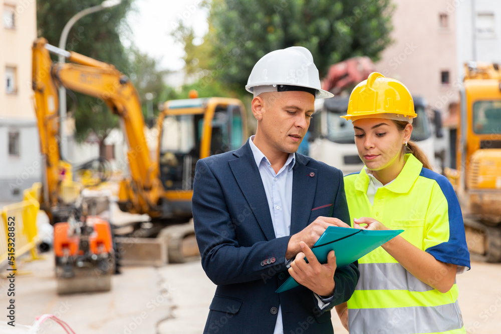 Civil engineers checking work process in construction site outdoors ...