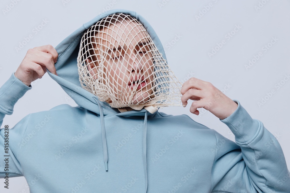 tortured, suffering from problems, a man with a mesh on his face stands ...