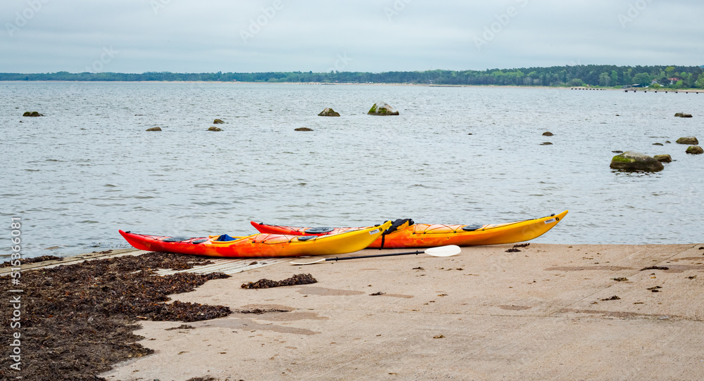 Kayaks on beach in front of Hallandsåsen hills in Bastad harbor, Sweden ...