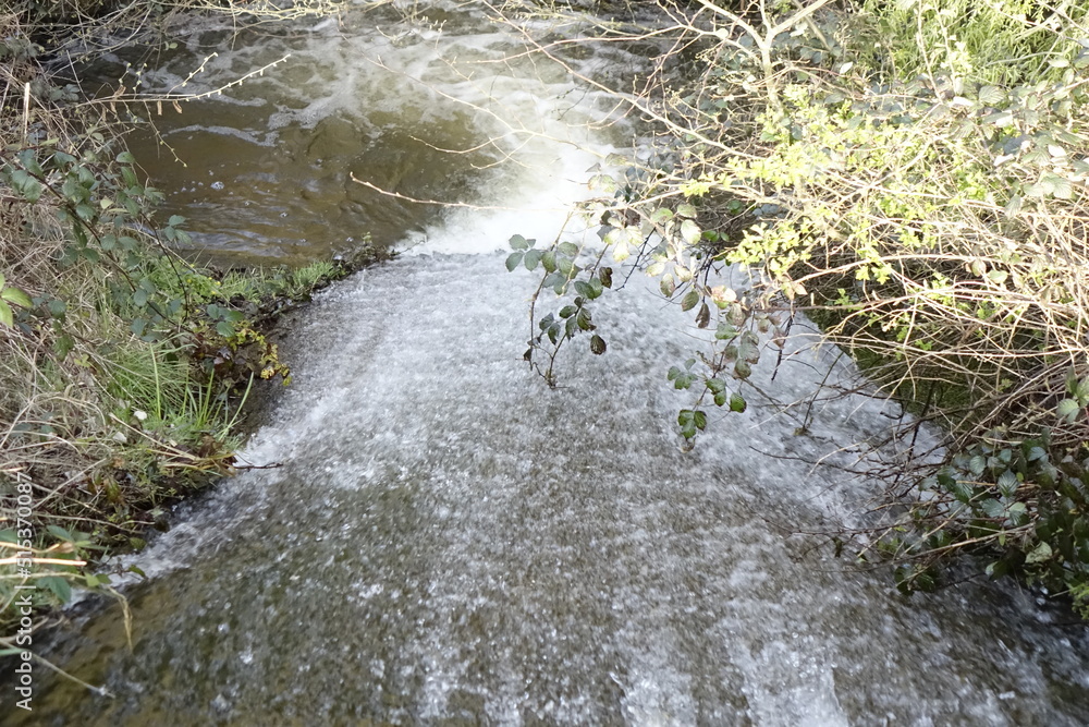 Water cascade with strong current at the overflow of small lake ...