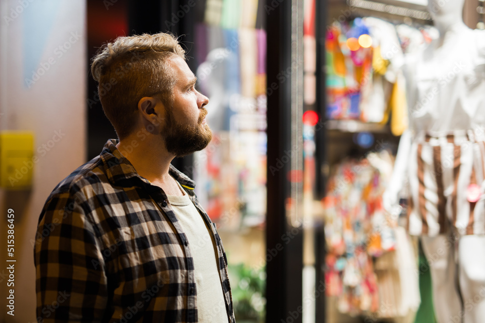 Man looking at shop window in evening street - store and shopaholic ...