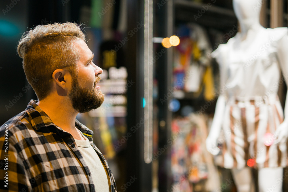 Man looking at shop window in evening street - store and shopaholic ...