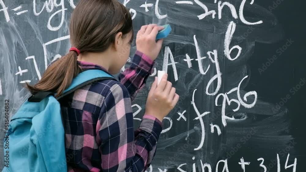Sad pupil trying to solve an example. Schoolgirl stands with her ...