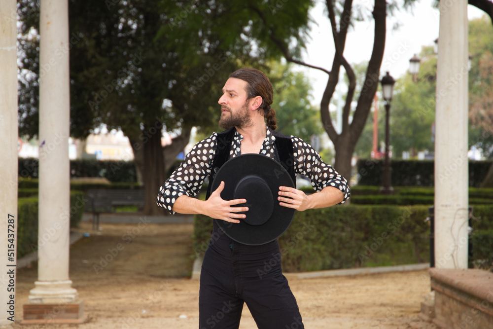 gypsy man dancing flamenco with long hair and beard in a park next to ...