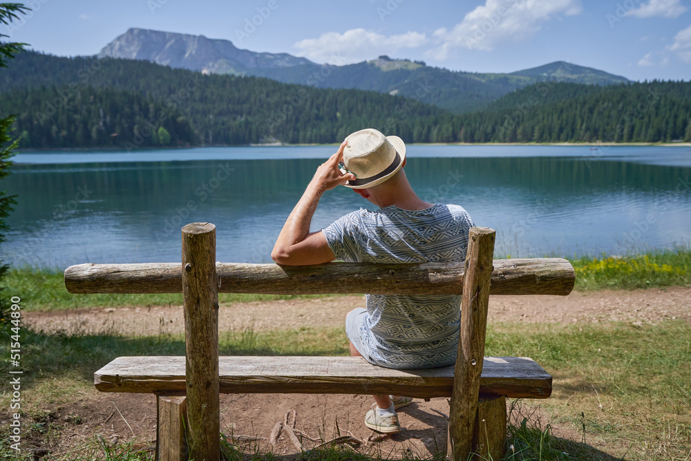 Foto de Relaxed man enjoys nature and life, looking at the lake and ...