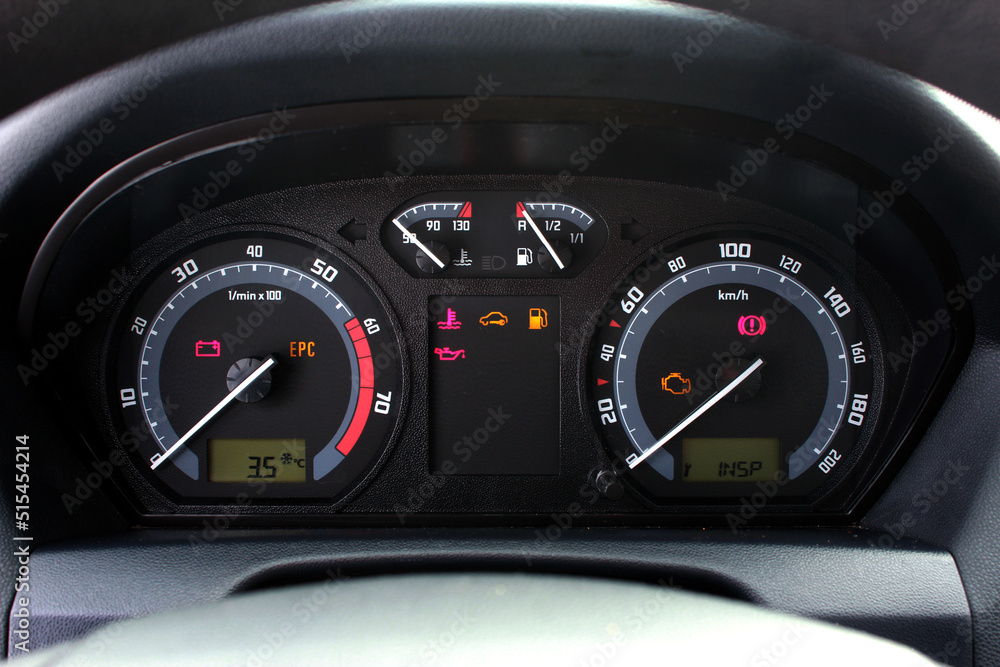 A close-up of a car panel with a speedometer indicating, oil and ...