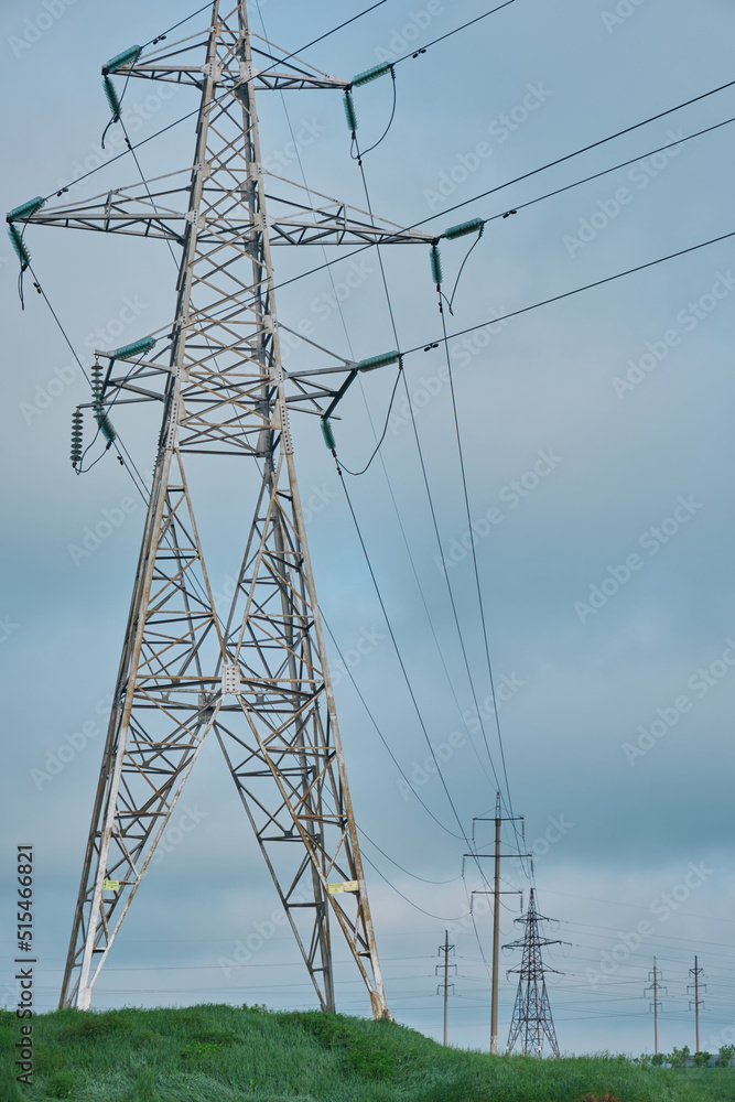High voltage electric pylon and electrical wire at green rice field and ...