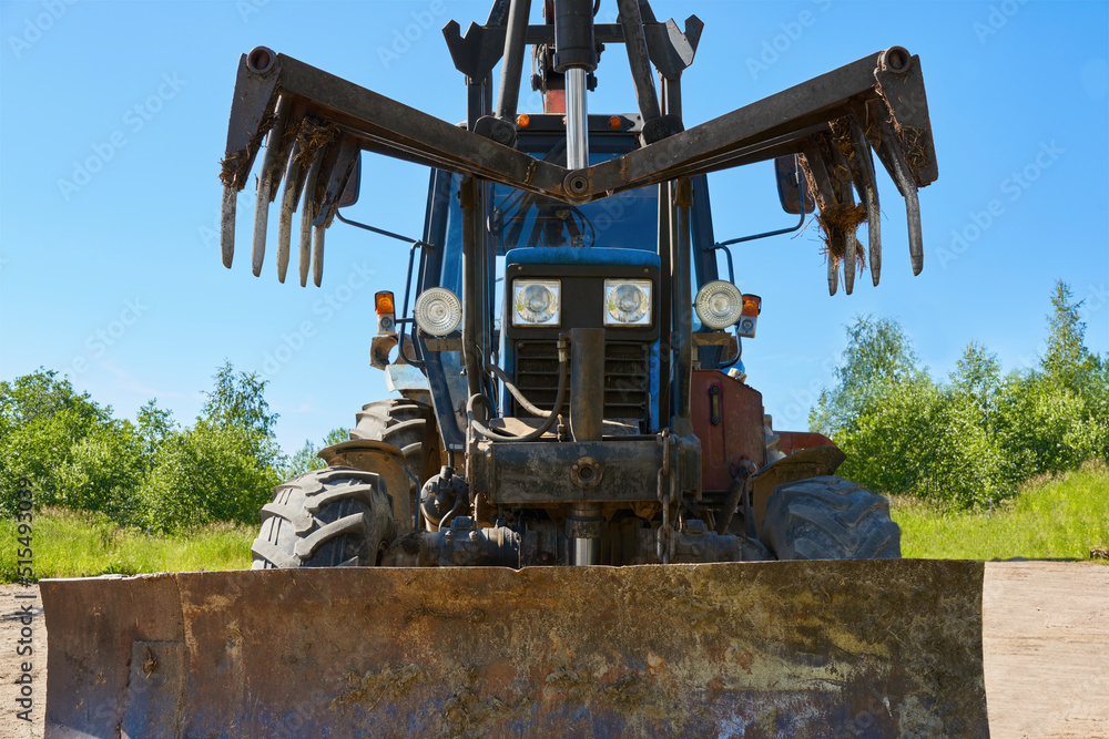Tractor with hydraulic grab and bucket. Tractor closeup front view ...
