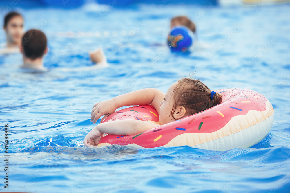 family vacation in summer in an outdoor pool with cool blue water, a ...