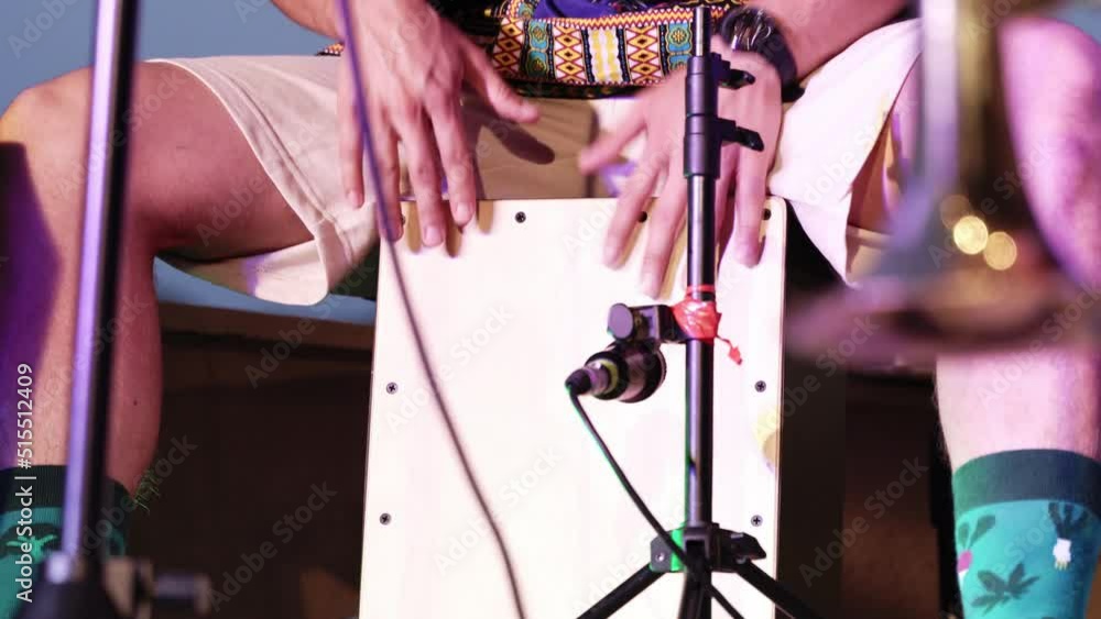 Close-up, a man with his hands plays the cajon during an acoustic rock ...