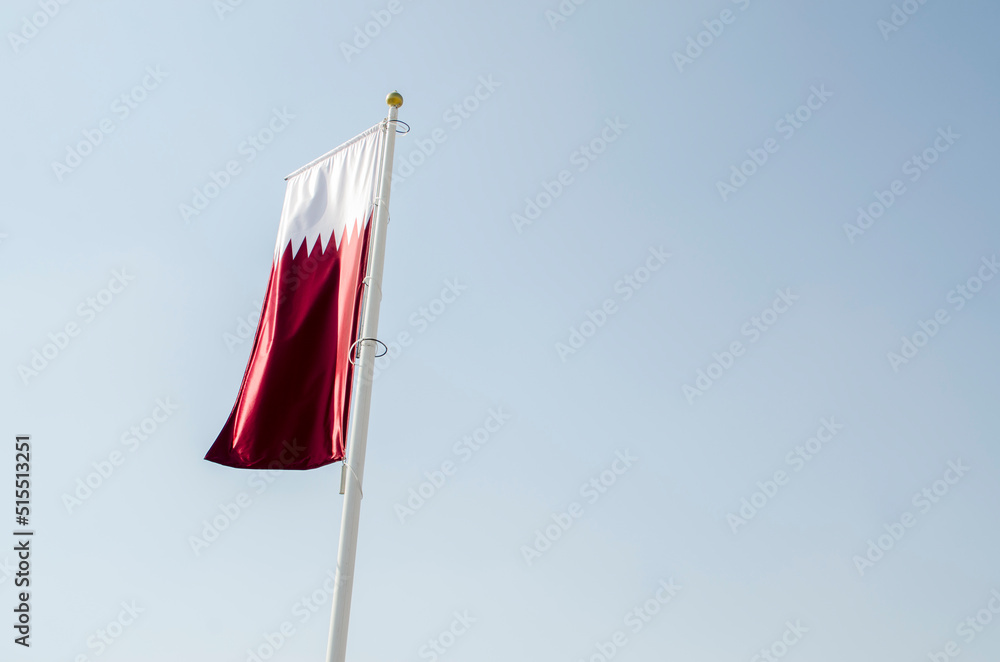 The national flag of Qatar. It is maroon with a broad white serrated ...
