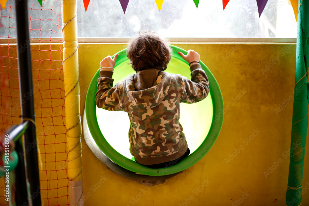Child playing in amusement park. Child in children's game. Boy entering ...