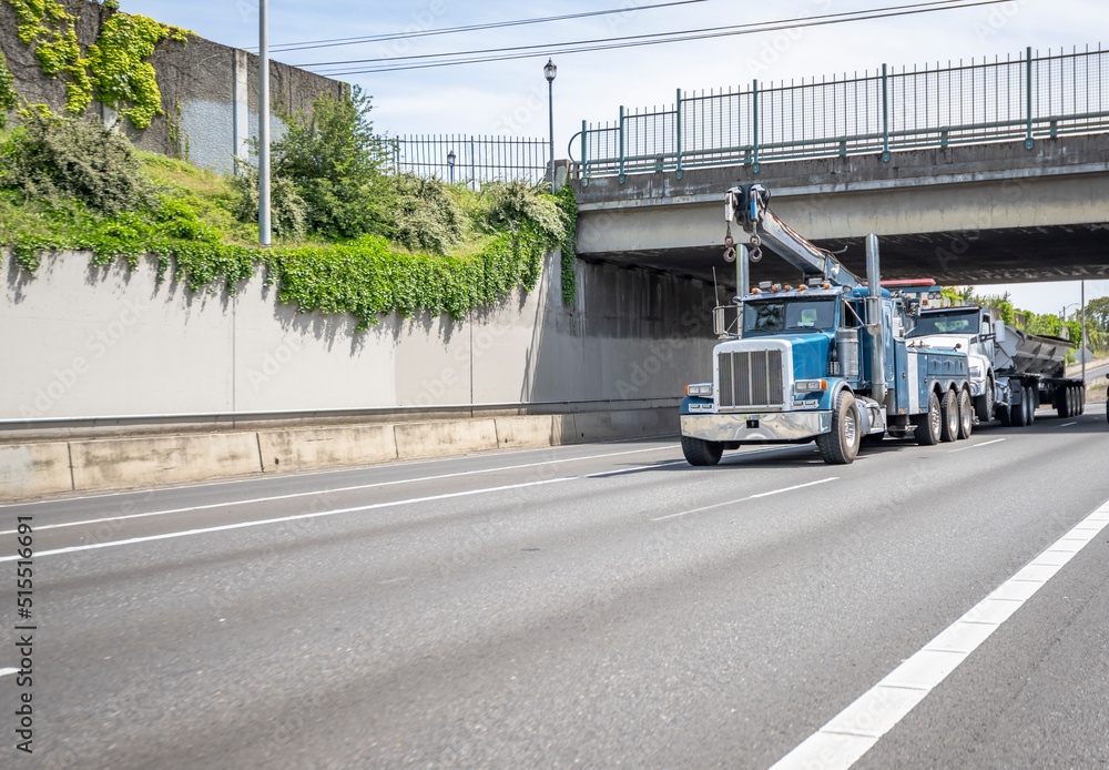 Towing semi truck with extended arrow transporting unexpectedly broken ...