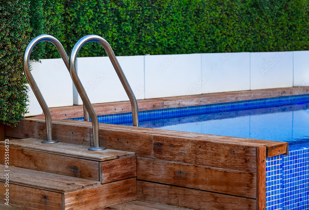 The planking of a swimming pool with stair and turquoise clear water ...