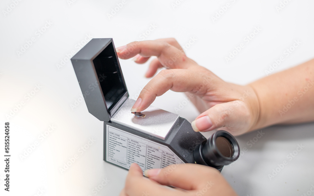 Female hand holding the precious stone for checking the specifications ...