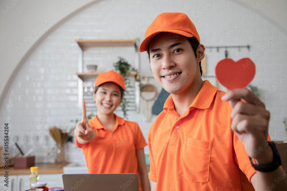 Teamwork of Asian caucasian delivery woman in orange uniform with ...