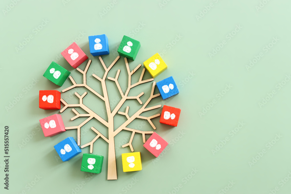 Business image of wooden tree with people icons over green background ...