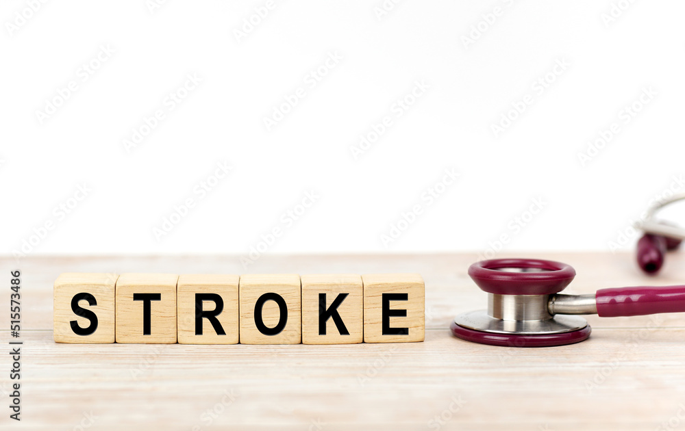 STROKE word written on wood block with stethoscope on white background ...