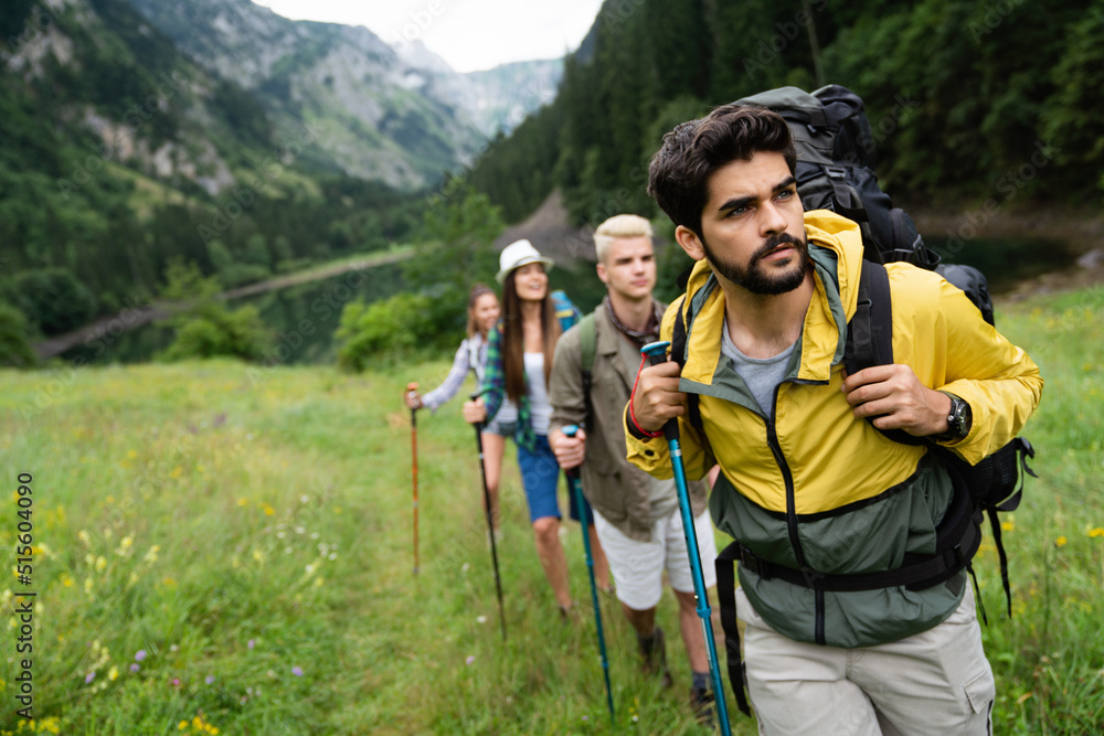Group of friends hiking together outdoors exploring the wilderness and ...