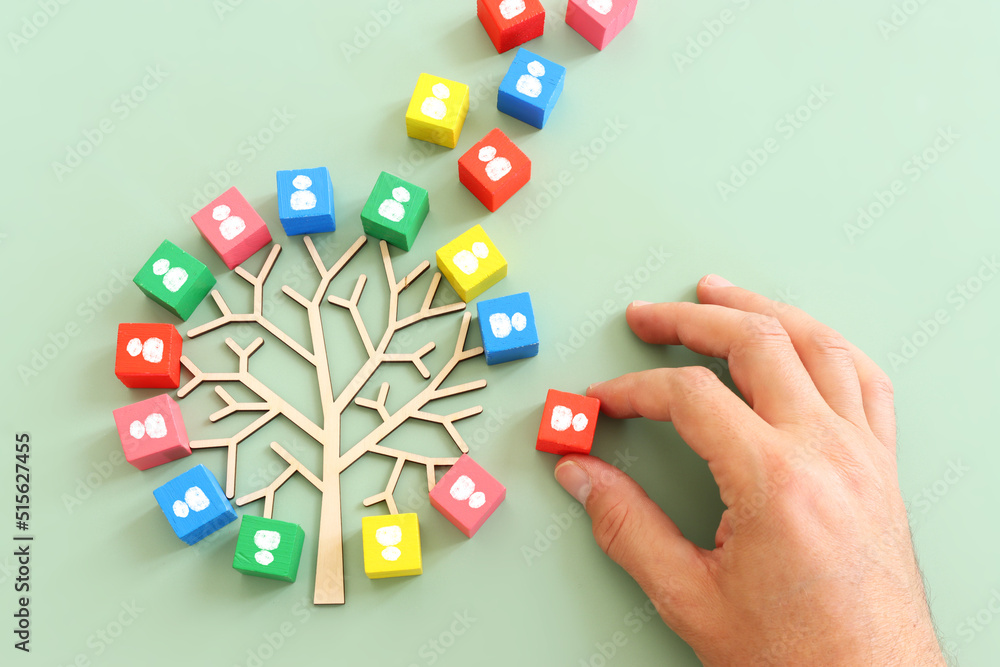 Business image of wooden tree with people icons over green background ...