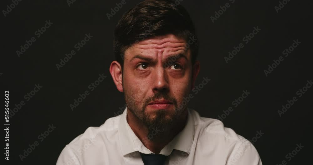 Nervous man looking worried and afraid against black studio background ...