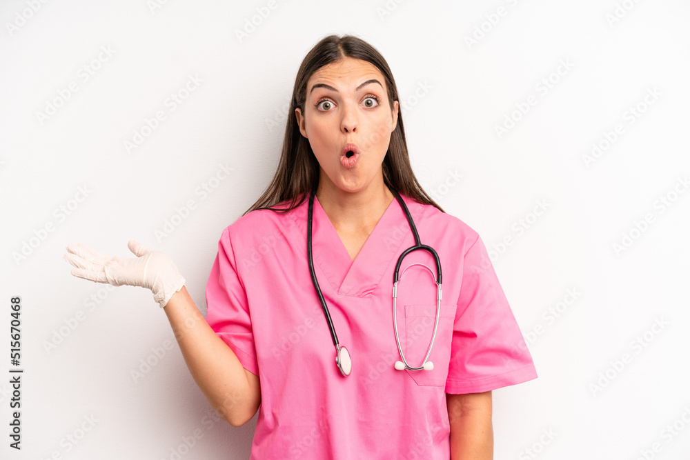 pretty woman looking surprised and shocked, with jaw dropped holding an ...