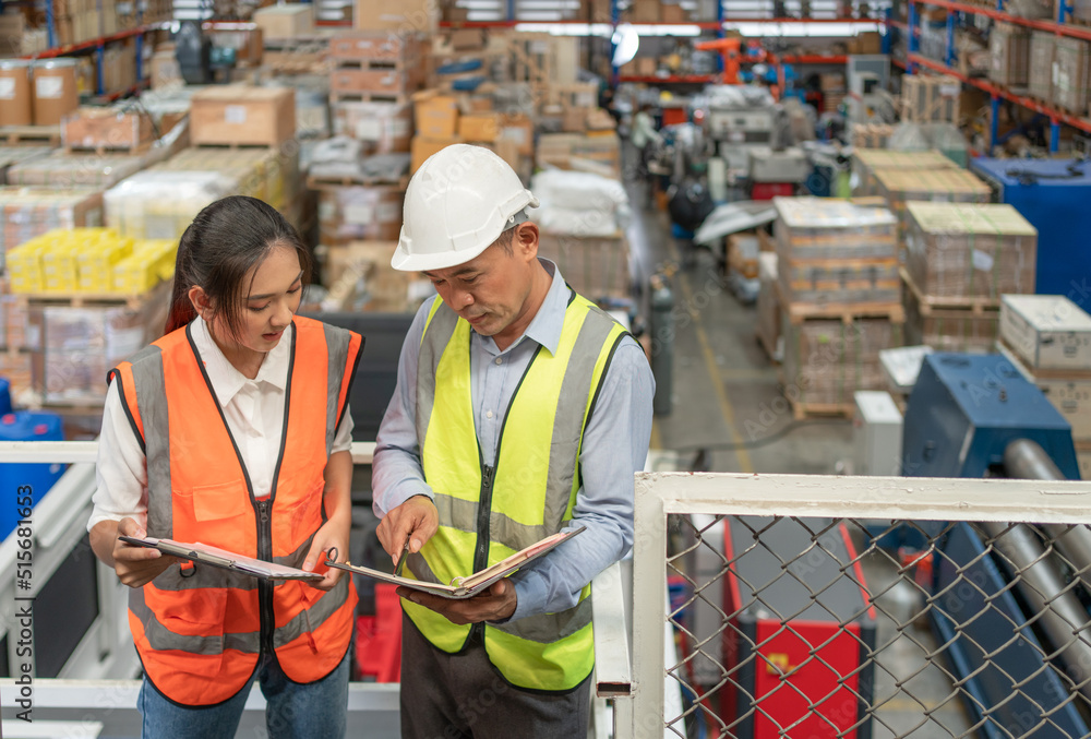 Male inventory supervisor explaining work plan in his notebook with young female worker at ...